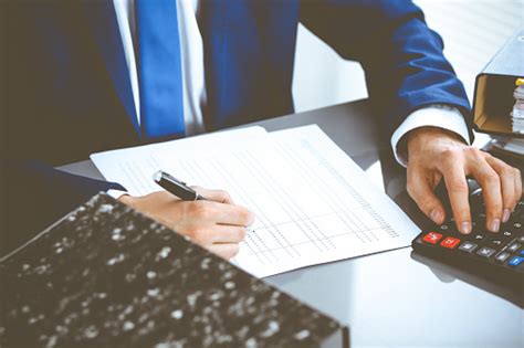 부기장 또는 재무 관리자가 보고서를 작성하거나 잔액을 계산하거나 검사합니다 국세청 조사관이 재무 문서를 확인합니다 비즈니스 세무 및 감사 개념 개념에 대한 스톡 사진 및