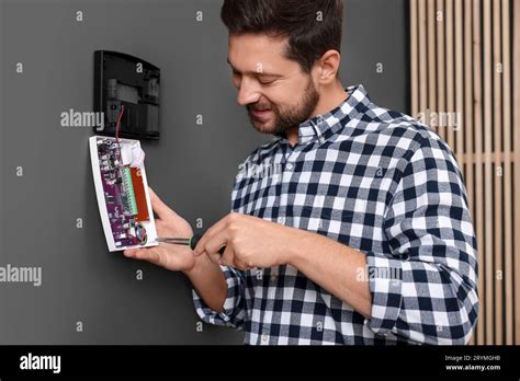 Man Installing Home Security Alarm System On Gray Wall Stock Photo Alamy