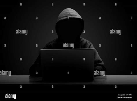 Mysterious Man Wearing Black Hoodie Using Laptop In The Dark Room