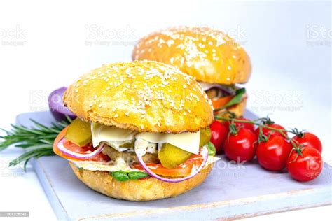 회색 보드에 두 개의 햄버거와 로즈마리와 토마토가 흰색 배경에 절연되어 있습니다 0명에 대한 스톡 사진 및 기타 이미지 0명