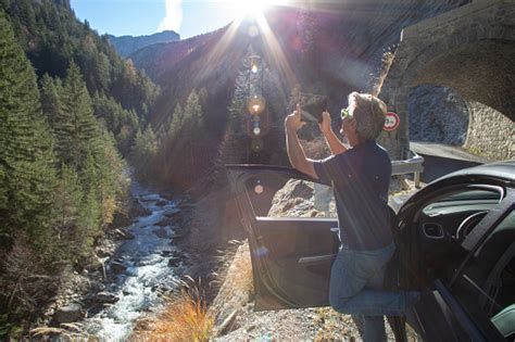 남자는 아침에 흐르는 강을 감상하기 위해 자동차 밖에서 휴식을 취합니다 55 59세에 대한 스톡 사진 및 기타 이미지 55
