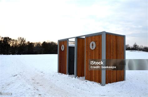 화학 화장실을 배치하기위한 폐쇄 케이지 보기 흉한 플라스틱 상자는 평평한 지붕과 벽에 나무 칸막이가있는 금속 집 안에 있습니다