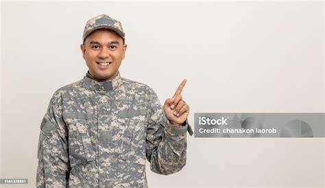 빈 공간을 가리 킵니다 스튜디오에 서 있는 아시아 남자 특수부대 병사 사령관 육군 군인 흰색 배경에 서 있는 제복을 입은 국가의