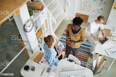 아늑한 사무실에서 함께 차트를 분석 하는 동안 보고서를 논의 심각한 바쁜 여러 민족 동료의 높은 각도 보기 그래프에 대한 스톡