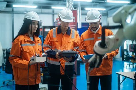 Group Of Robotics Engineers Working With Programming And Manipulating Robot Hand Industrial