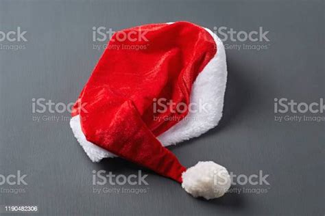 산타 클로스 빨간 모자 한 개는 어두운 콘크리트 책상 위에 놓여 있습니다 클로즈업 12월에 대한 스톡 사진 및 기타 이미지 12월 개인 장식품 겨울 Istock