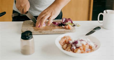 가정 요리 개념입니다 현대 흰색 부엌에서 나무 판에 칼로 양파와 닭고기 필레를 자르는 사람 홈 피자를 만드는 과정 손을 닫습니다 사진 Unsplash의 음식 이미지