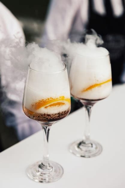 Premium Photo Two Glasses Of Cocktail With A Cloud Of Smoke On The Top