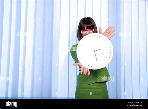 A Pretty Business Woman Hiding Behind A Clock Stock Photo Alamy