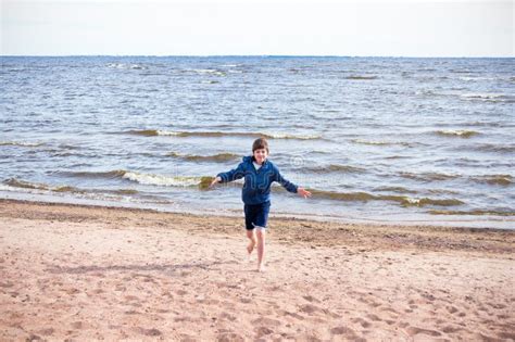 Garçon Heureux En Veste Bleue Et Shorts Pieds Nus Courir Sur Le Sable