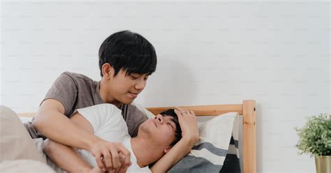 아시아 게이 커플은 집에서 침대에서 키스하고 포옹합니다 젊은 아시아 Lgbtq 남성들은 아침 컨셉으로 집에서 침실에서 깨어난 후 낭만적인 시간을 보내는 행복한 휴식을 함께