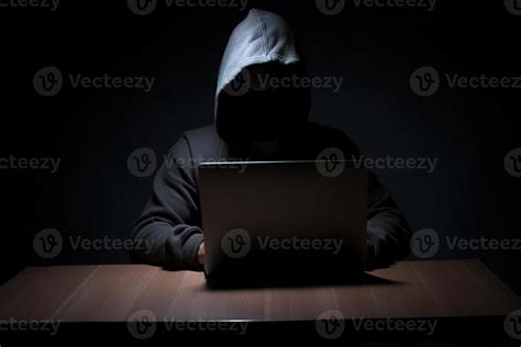 Hacker Wearing Black Hoodie Using Laptop Computer While Working On Dark