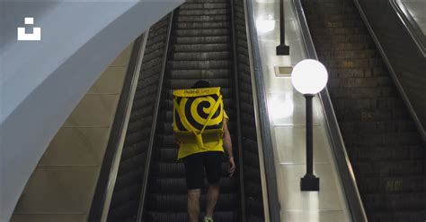 노란색과 검은색 배트맨 셔츠를 입고 검은색 반바지를 입고 검은 계단을 걷는 사람 사진 Unsplash의 무료 도시 이미지