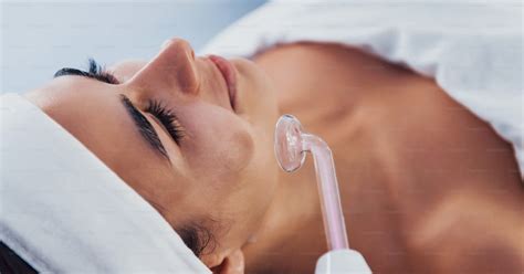 스파 살롱에 누워 있는 여성의 모습을 닫고 현대적인 장치를 사용하여 얼굴 청소 절차를 수행합니다 사진 Unsplash의 인간의 얼굴 이미지