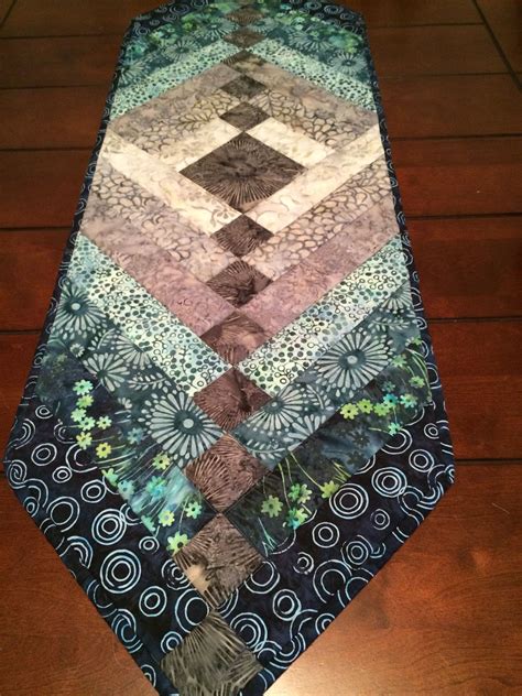 A Quilted Table Runner On Top Of A Wooden Floor