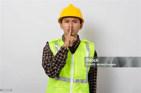 하얀 배경에 고립된 입술에 손가락을 대고 조용히 해달라고 요청하는 젊은 아시아 건설 노동자 18 19세에 대한 스톡 사진 및 기타 이미지 18 19세 개발 건설 산업