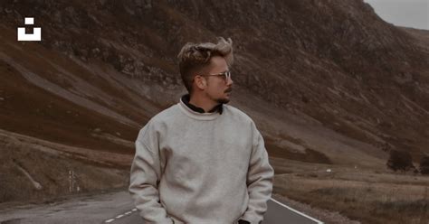 흰색 스웨터와 파란색 데님 청바지를 입은 남자가 낮에 회색 아스팔트 도로에 서 있다 사진 Unsplash의 무료 스코틀랜드