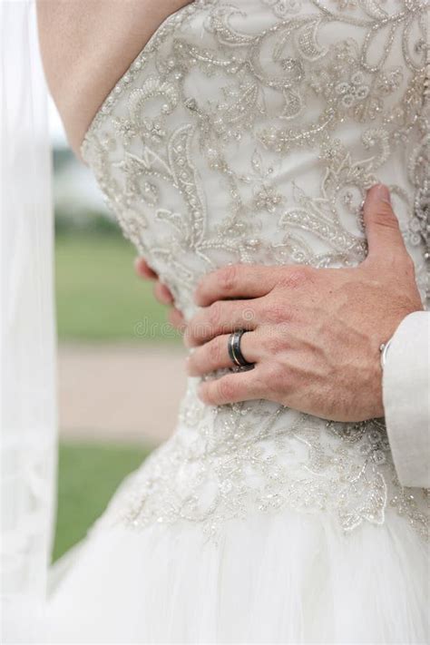 The Groom Hugs The Bride Dressed In A White Wedding Dress Stock Image