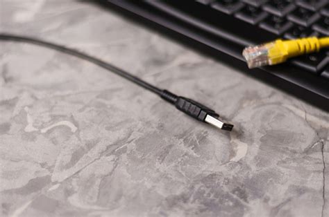 플라스틱 커넥터와 Usb 케이블 및 복사 공간 오래 착용 하 고 긁힌 콘크리트 바닥에 검은 키보드와 컴퓨터에 대 한 노란색 네트워크 케이블 0명에 대한 스톡 사진 및 기타