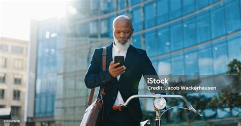 자전거 전화 및 의사 소통이나 출퇴근을 위해 도시에서 야외에서 비즈니스 흑인 남성과 생각합니다 건물 모바일 앱의 길 찾기 및 자전거를 위한 친환경 교통 수단을 갖춘 진지한