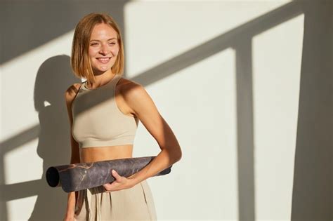 Premium Photo Young Sporty Smiling Woman Posing With Yoga Mat After