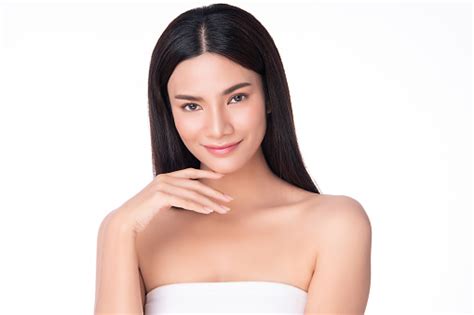 깨끗 하고 신선한 피부와 함께 부드러운 뺨과 미소를 만지는 아름 다운 젊은 아시아 여자 행복과 쾌활한 흰색 배경에 고립 아름다움과 화장품 개념 건강관리와 의술에 대한 스톡