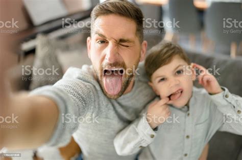 아버지와 아들은 소파에서 함께 셀카를 찍고 찡그린 얼굴을 만드는 시간을 보냅니다 성인에 대한 스톡 사진 및 기타 이미지 성인 소년 아이 Istock