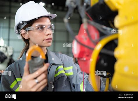In The Robots Warehouse A Female Engineer Inspects The Electrical