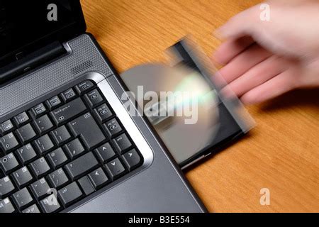 Inserting A CD Into A CD Rom Drive On A Laptop Computer Stock Photo Alamy
