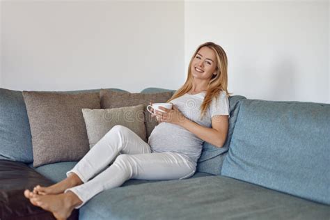 Pretty Barefoot Young Pregnant Woman Relaxing On A Couch Stock Image