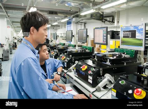 Workers Assemble Hand Held Inventory Computer Devices On The Assembly Line At The Venture Corp