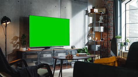 현대적인 거실의 Tv에 크로마 키 그린 스크린 디스플레이 스마트 텔레비전 세트 소파 화분에 심은 식물이 있는 현대적인 아파트