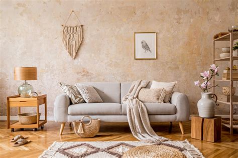 디자인 회색 소파 나무 커피 테이블 선반 큐브 카펫 등나무 푸프 식물 사진 프레임 테이블 램프와 가정 장식우아한 액세서리와 거실