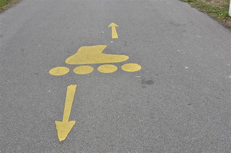 롤러 블레이드 아스팔트 트랙롤러 스케이트와 반대 방향으로 나타나는 화살표의 노란색 아이콘 스포츠 와 레크리에이션을위한 스케이트 트랙 0명에 대한 스톡 사진 및 기타 이미지