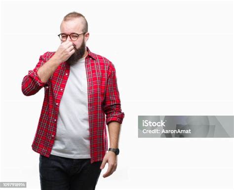 젊은 백인 Hipster 사람 고립 된 배경 뭔가 냄새 나 고 역 겨 운 냄새 참을 냄새 코에 손가락으로 잡고 숨을 안경 착용 나쁜 냄새 개념입니다 공포 무서움에 대한 스톡
