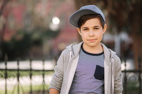 파란 모자를 쓴 세련된 어린 소년이 사진을 찍기 위해 밖에서 포즈를 취하고 있습니다 여름 날씨를 따라 도시를 걷는 소년 귀여운에 대한 스톡 사진 및 기타 이미지 Istock