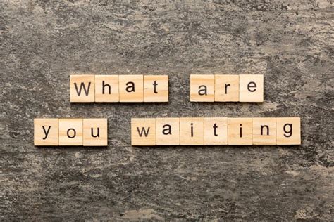 what are you waiting word written on wood block what are you waiting text on cement table for