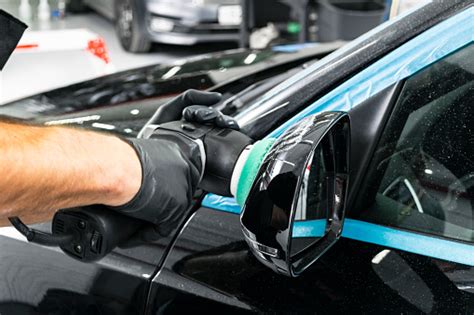 자동차 폴란드어 왁 스 작업자 연마 하기 전에 적용 보호 테이프를 손 버프 하 고 차를 연마입니다 자동차 적입니다 남자 손에서