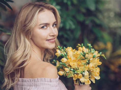 Красивая улыбающаяся девушка с букетом желтых цветов в руке обои для рабочего стола картинки