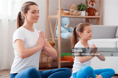 수평 스튜디오 사진입니다 젊은 엄마와 딸 아이 명상 기도에 고정 된 손 깊은 호흡 오프닝 생활 차크라 우주에서 내려 오는 축복