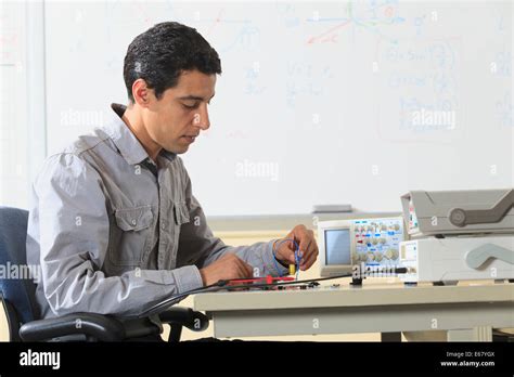 Engineering Student Inserting Component Into Prototyping Breadboard For An Electronics Lab