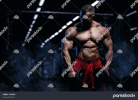 تمرین بدنساز مرد عضلانی در باشگاه و ژست گرفتن تمرین ماهیچه ای مناسب