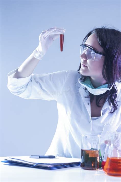 Técnico De Laboratorio De Sexo Femenino Looking En El Frasco Llenado De La Sustancia Química