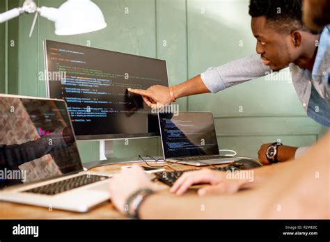 Two Young Programmers Working With Program Code Sitting At The