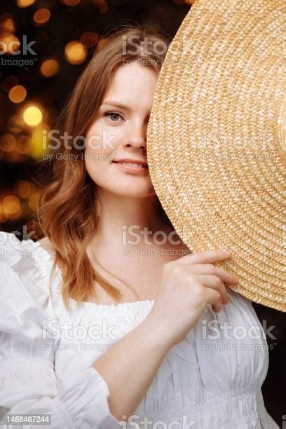 흰 드레스를 입은 여자는 밀짚 모자로 얼굴의 절반을 가립니다 귀여운에 대한 스톡 사진 및 기타 이미지 귀여운 드레스 러시아 Istock