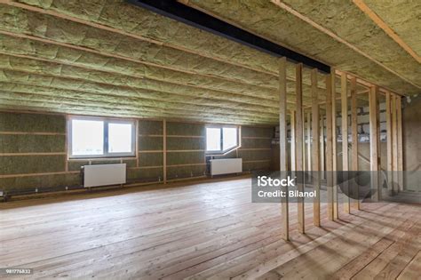 건설과 오크 바닥 벽과 천장 바위 모직 미래의 벽에 대 한 낮은 다락방 창과 목조 프레임 아래 라디에이터 난방과 절연 큰 빛 넓은 빈 룸의 리노베이션 0명에 대한 스톡 사진