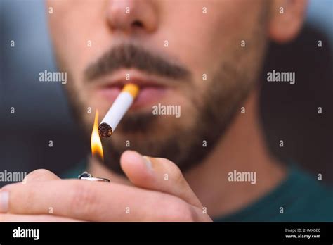 Closeup Of Young Man Lighting Cigarette With Lighter Smoking Cigarette