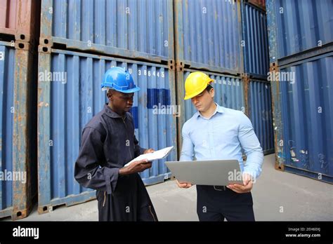 Engineer Or Supervisor Checking And Control Loading Containers Box From Cargo At Harbor Foreman
