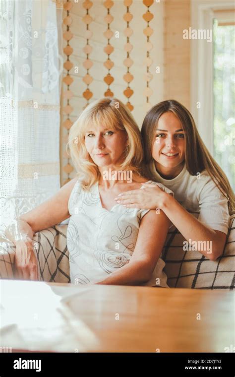 Loving Adult 20s Daughter Hug Elderly Mother From Behind While Mom
