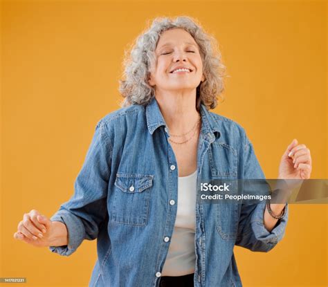 미소 짓는 성숙한 여성은 축하하고 춤을 추며 평온하고 행복하고 은퇴에 흥분합니다 긍정적이고 트렌디하며 펑키 한 긍정적 인 시니어 레이디 무료 정신 댄스 및 스튜디오에서의